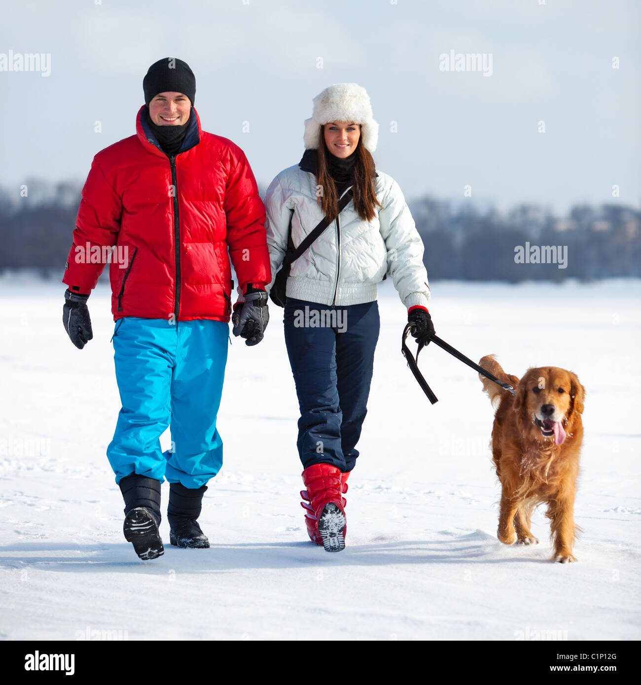 Young couple walking with dog Stock Photo - Alamy