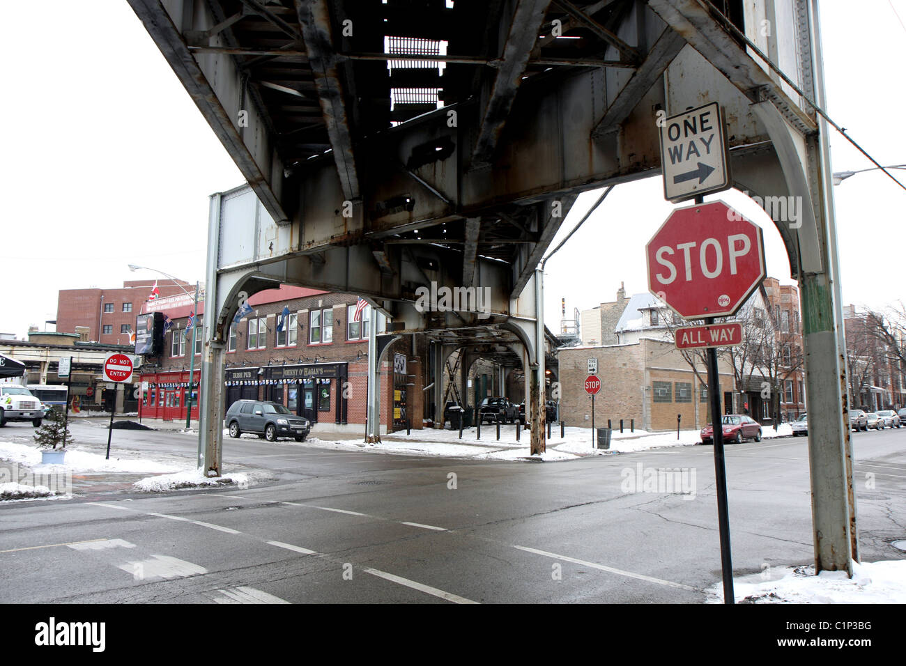 Street junction with stop sign in Chicago with elevated commuter train ...