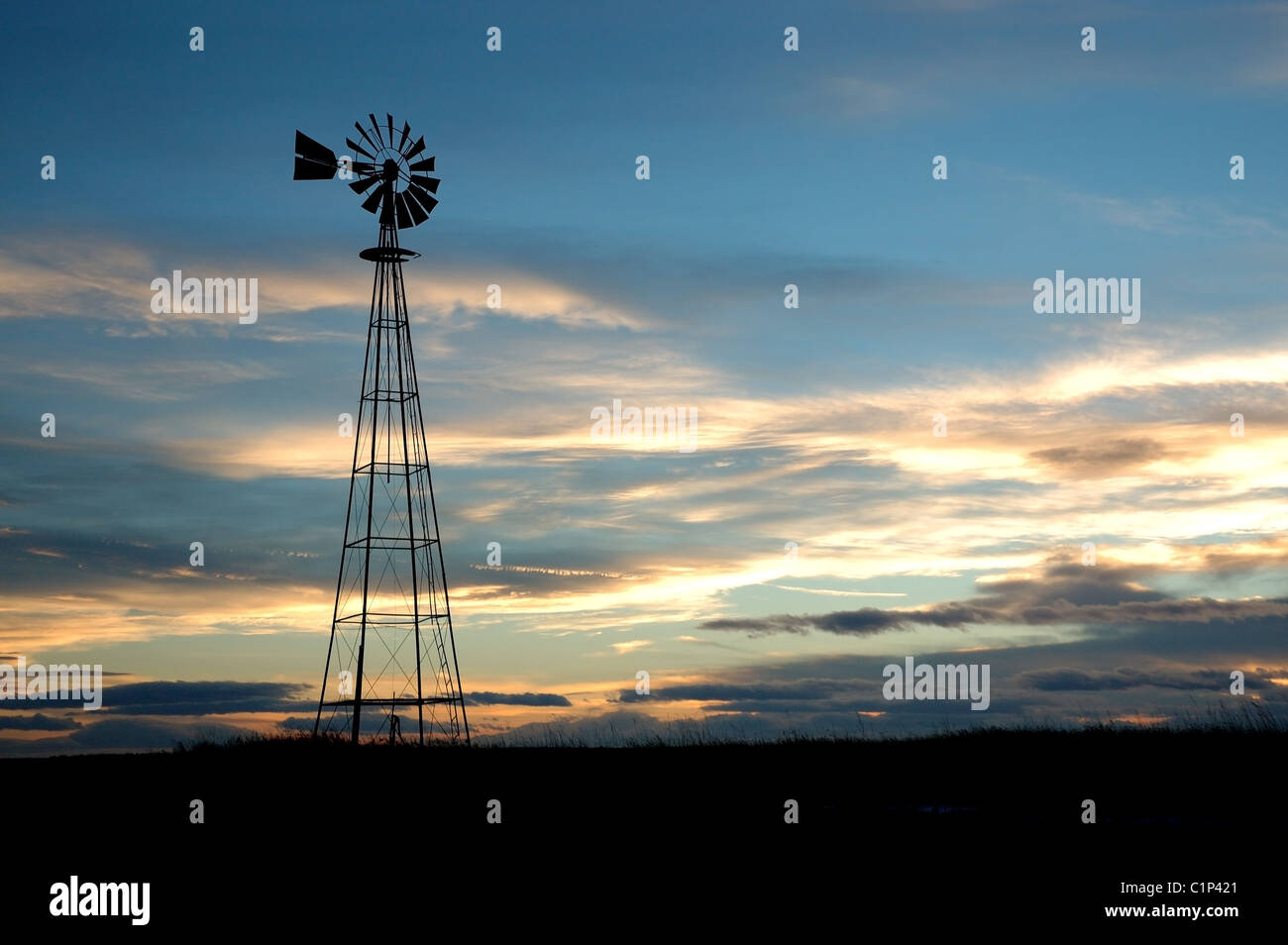 Antique windmill on the prairie at sunset Stock Photo - Alamy