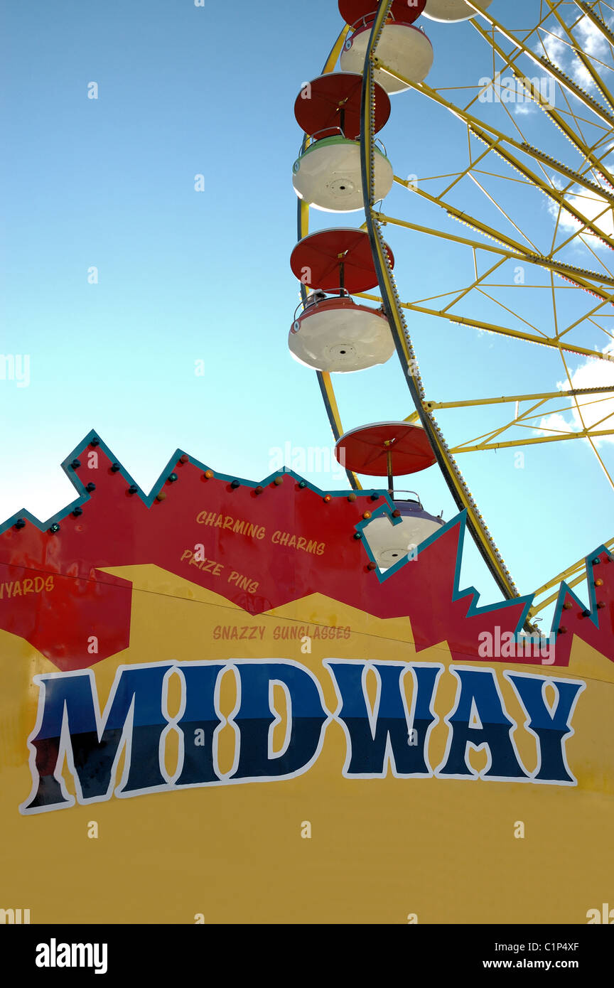 A midway sign with a ferris wheel ride in the background Stock Photo ...