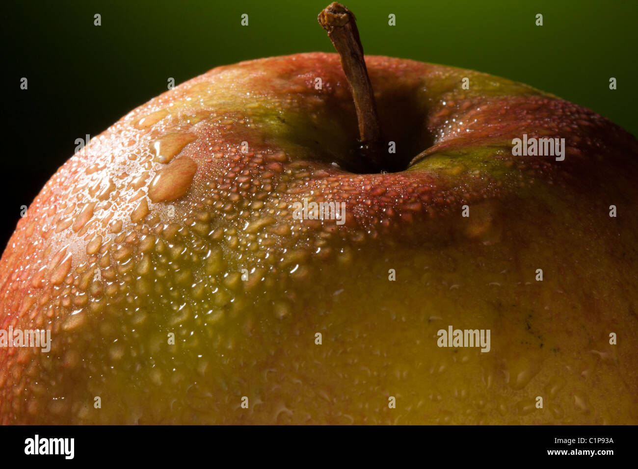 Wet Apple with water drops on green background Stock Photo - Alamy