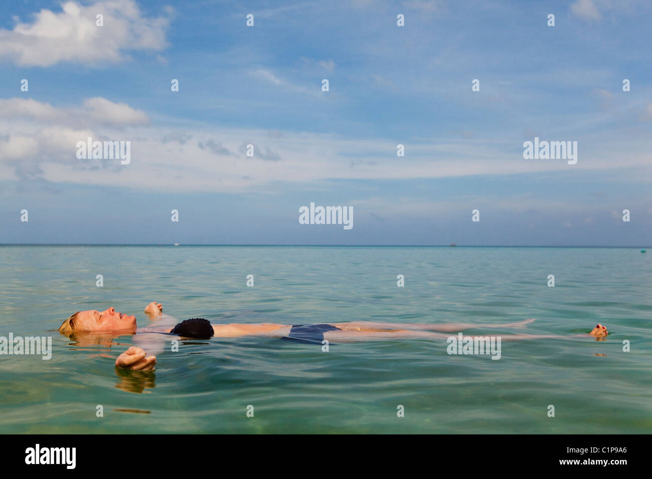 Woman floating on sea Stock Photo - Alamy