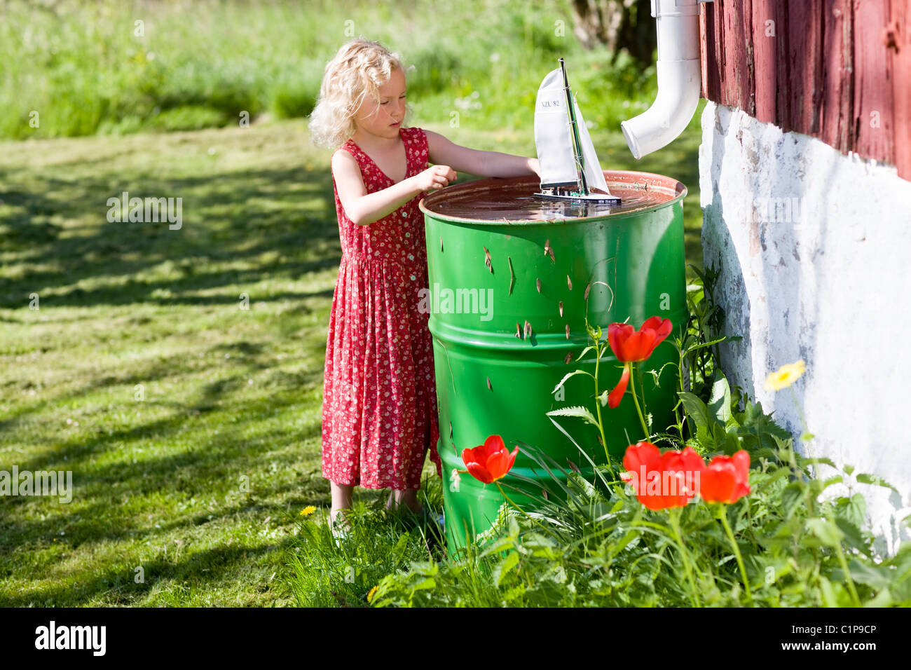 Girl playing with toy boat in garden Stock Photo - Alamy