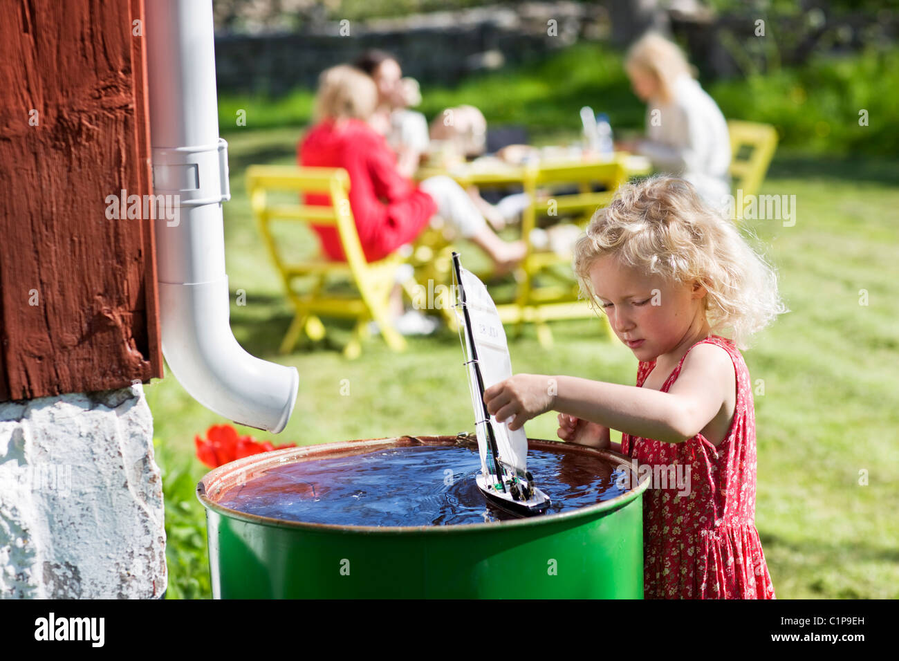 Girl playing with toy boat in garden Stock Photo - Alamy
