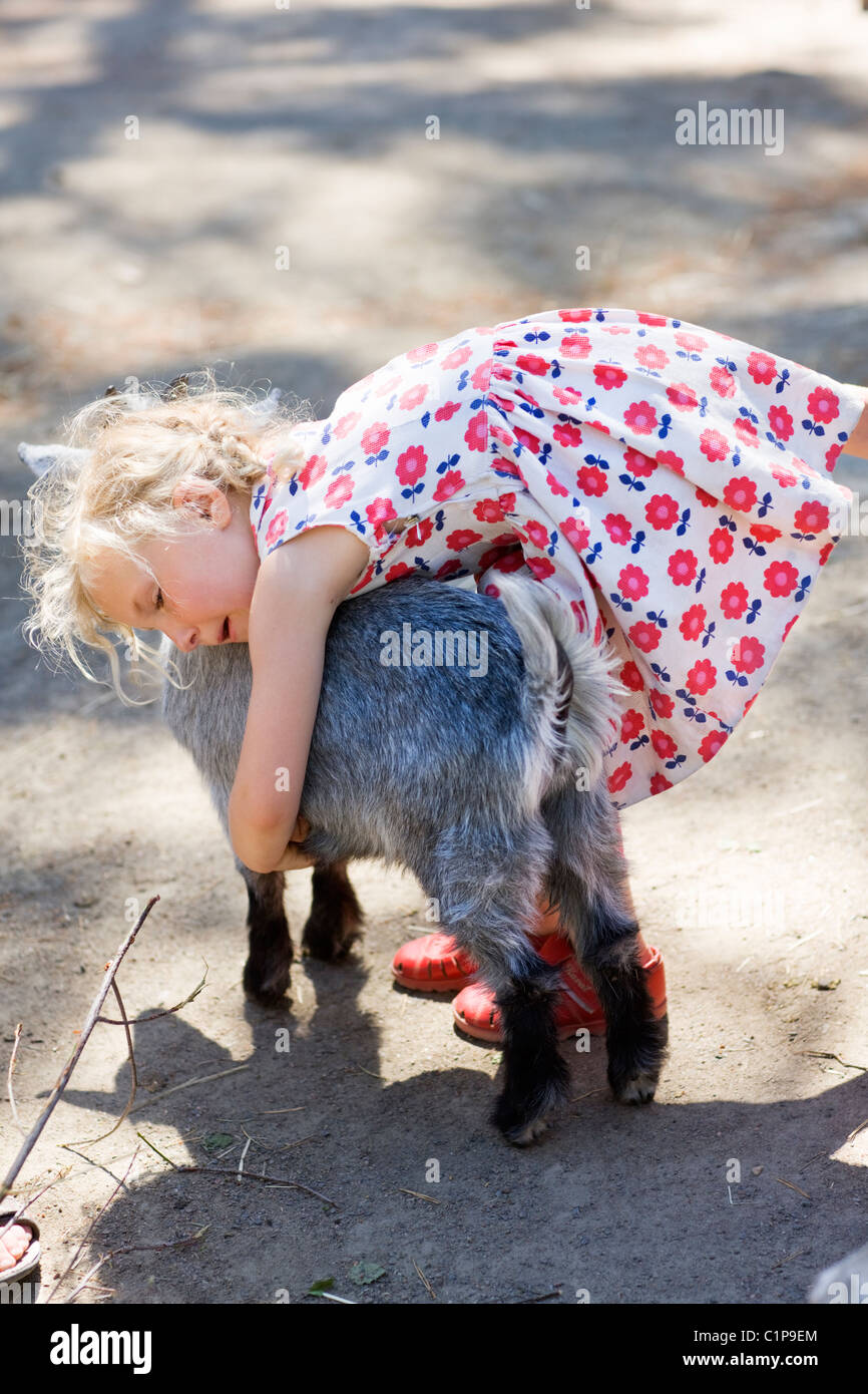 Girl embracing goat at zoo Stock Photo - Alamy