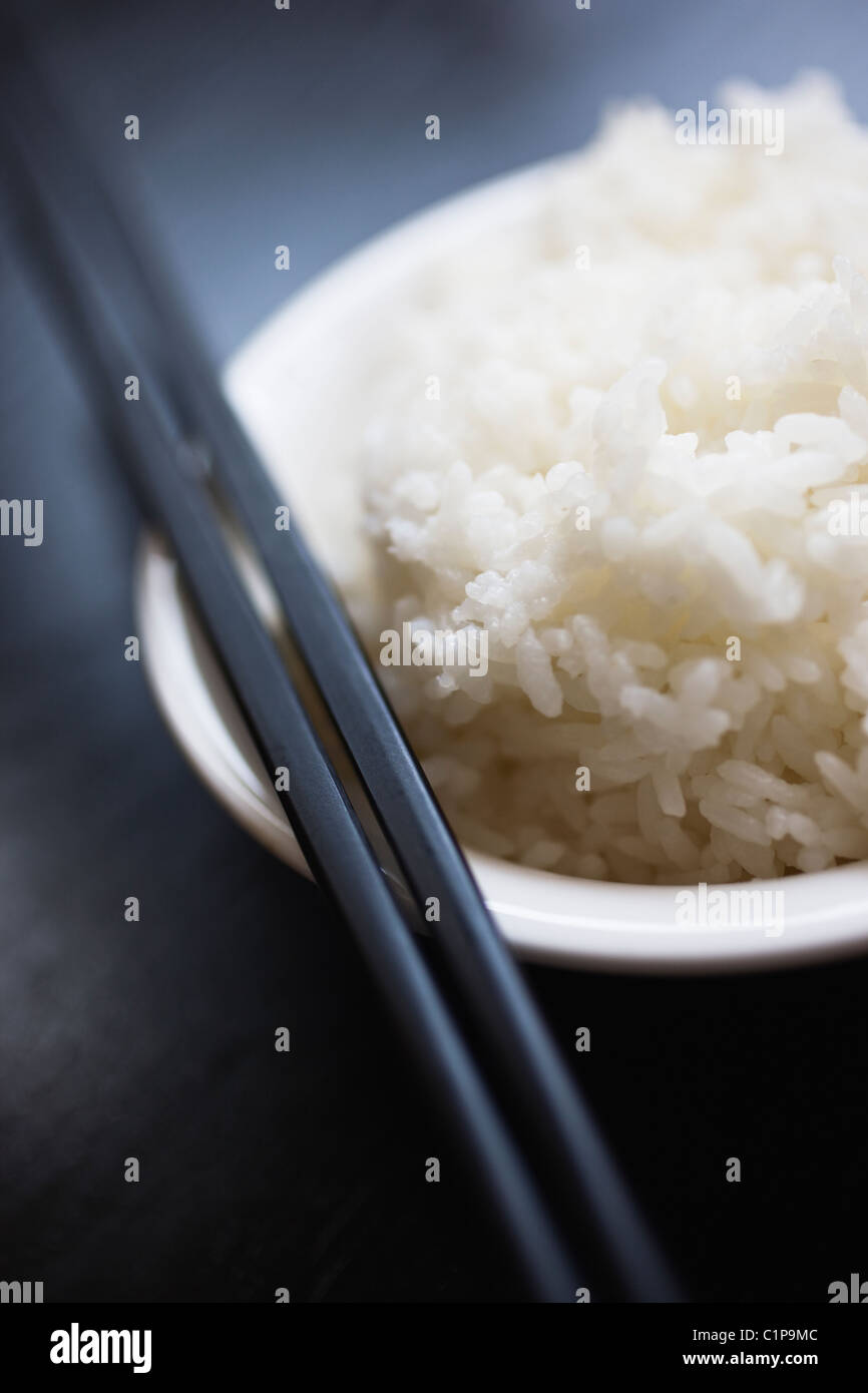 Chopsticks on bowl with rice Stock Photo - Alamy
