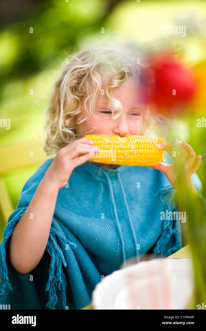 Girl eating corn on the cob outdoors Stock Photo - Alamy