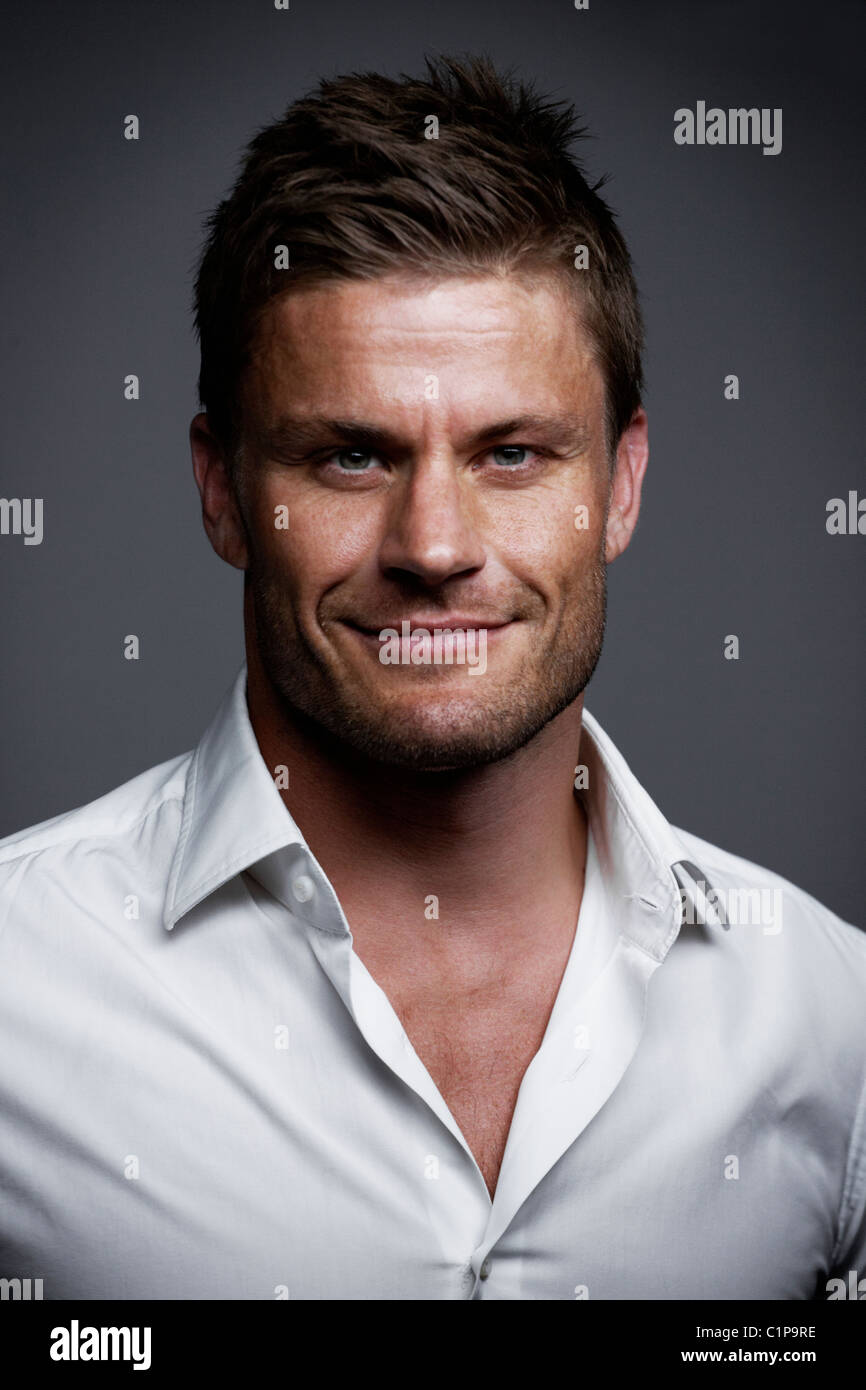 Portrait of smiling man against grey background Stock Photo - Alamy