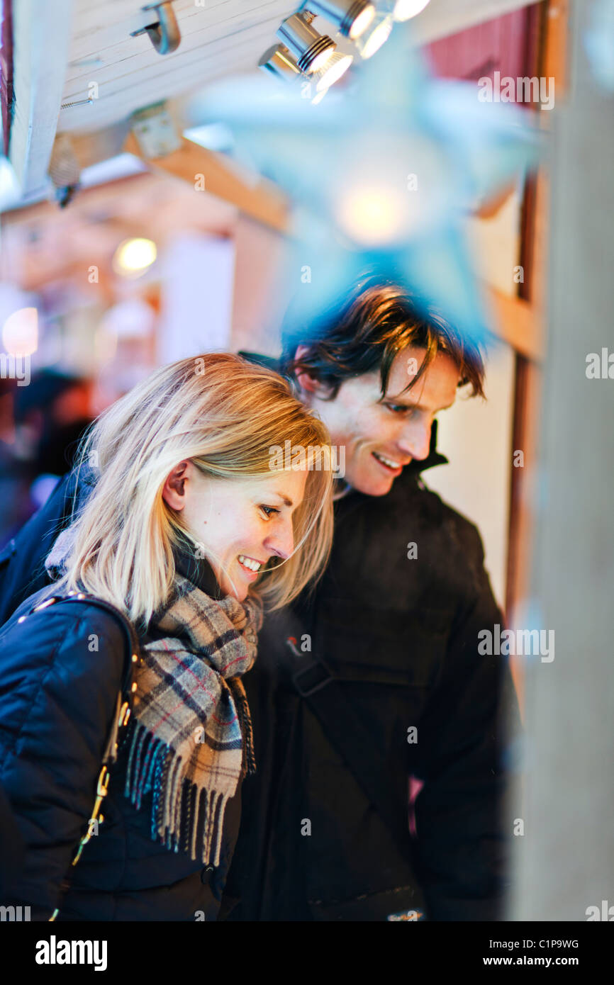 Couple standing in front of stall Stock Photo - Alamy