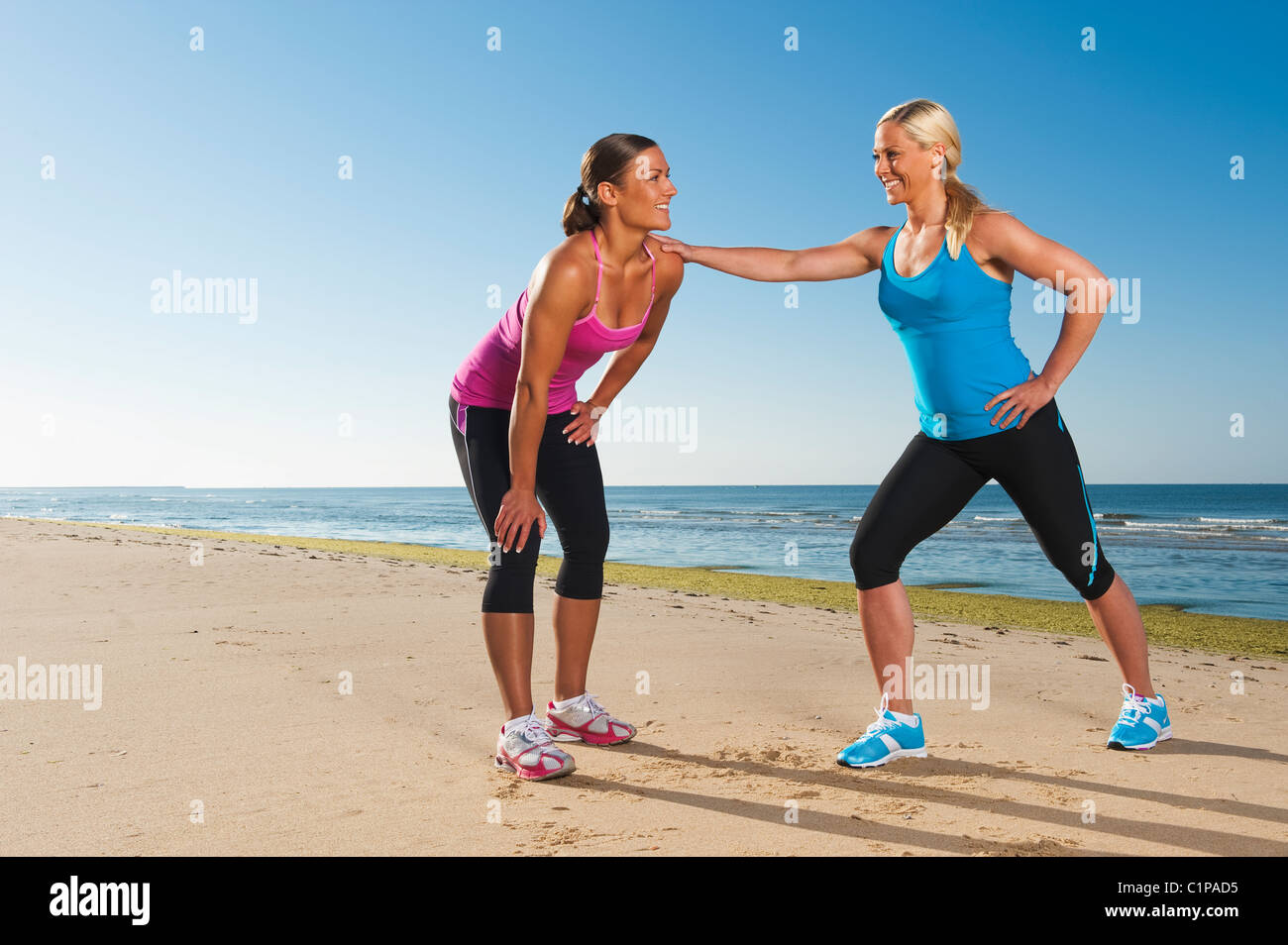 Two women exercising together on beach Stock Photo - Alamy