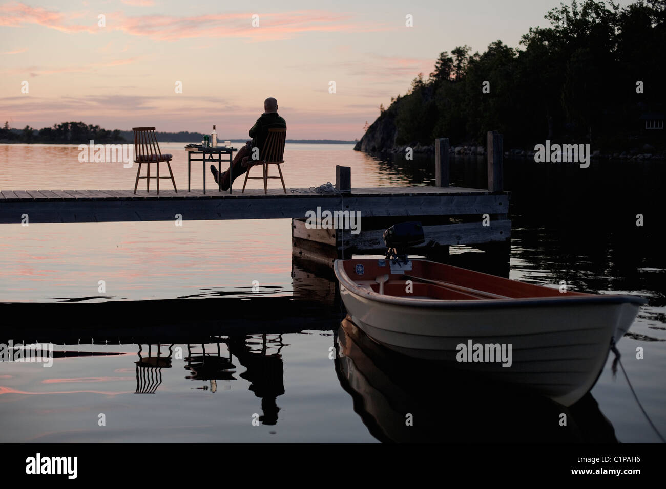 Silhouette of man sitting on pier Stock Photo - Alamy