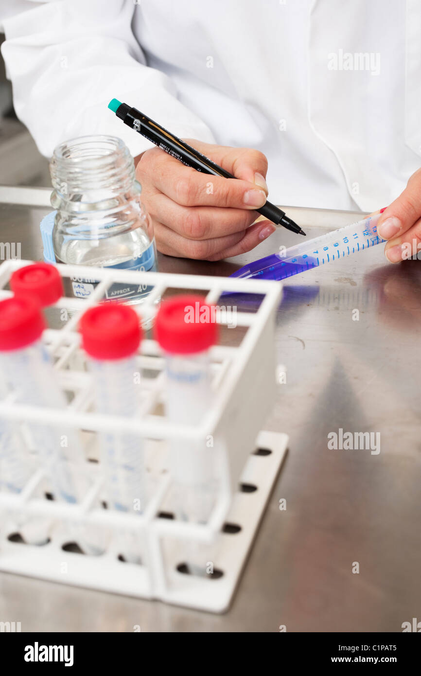 Scientist writing on test tube Stock Photo - Alamy
