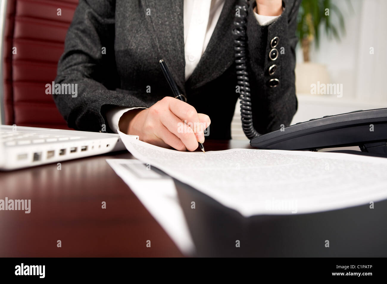 Close-up of human hand writing something at the bottom of business ...
