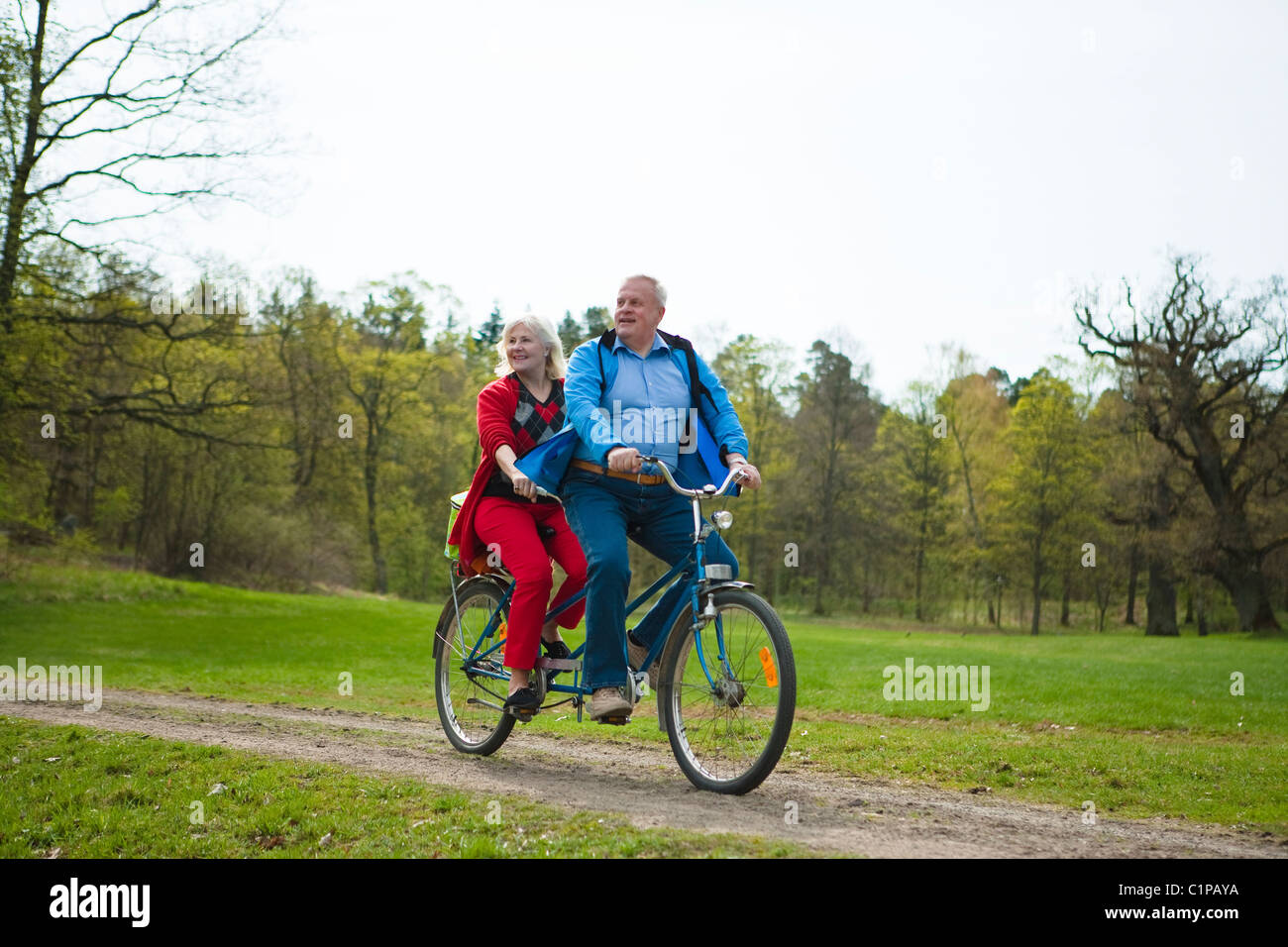 Senior couple riding on tandem bicycle Stock Photo - Alamy