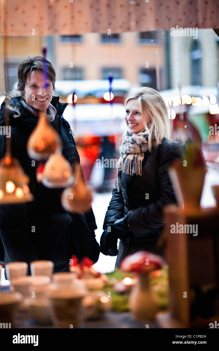 Couple standing in front of stall Stock Photo - Alamy