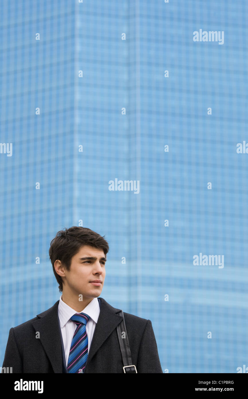 Image of pensive guy looking aside on the background of modern office ...