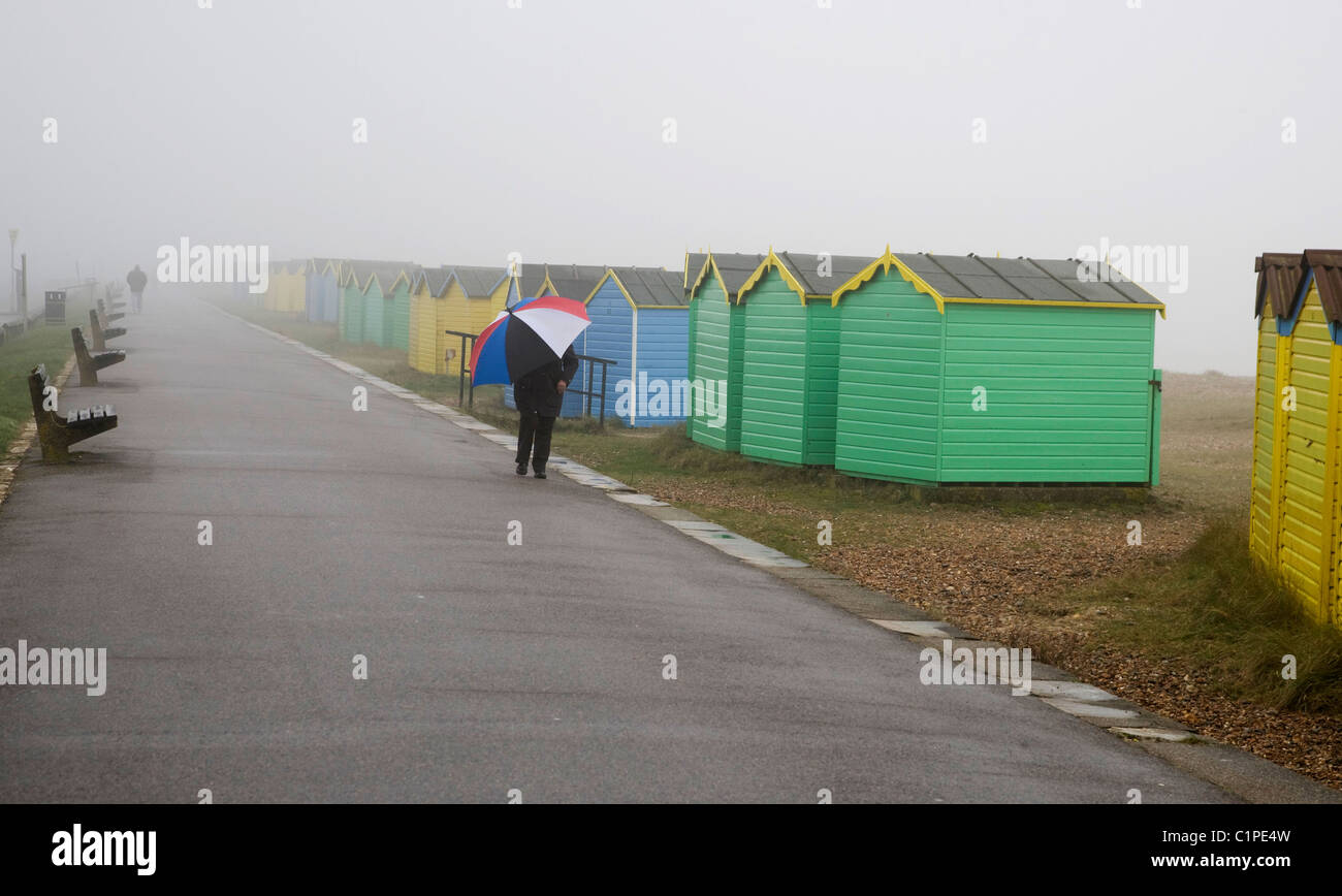 Lady walking past beach huts hi-res stock photography and images - Alamy