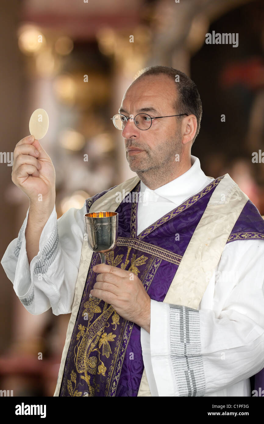 Catholic priest during communion in worship Stock Photo - Alamy