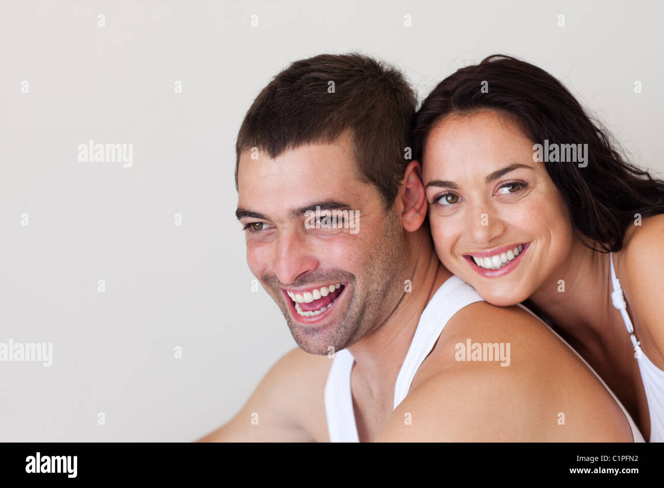 Smiling couple sitting on the bed Stock Photo - Alamy