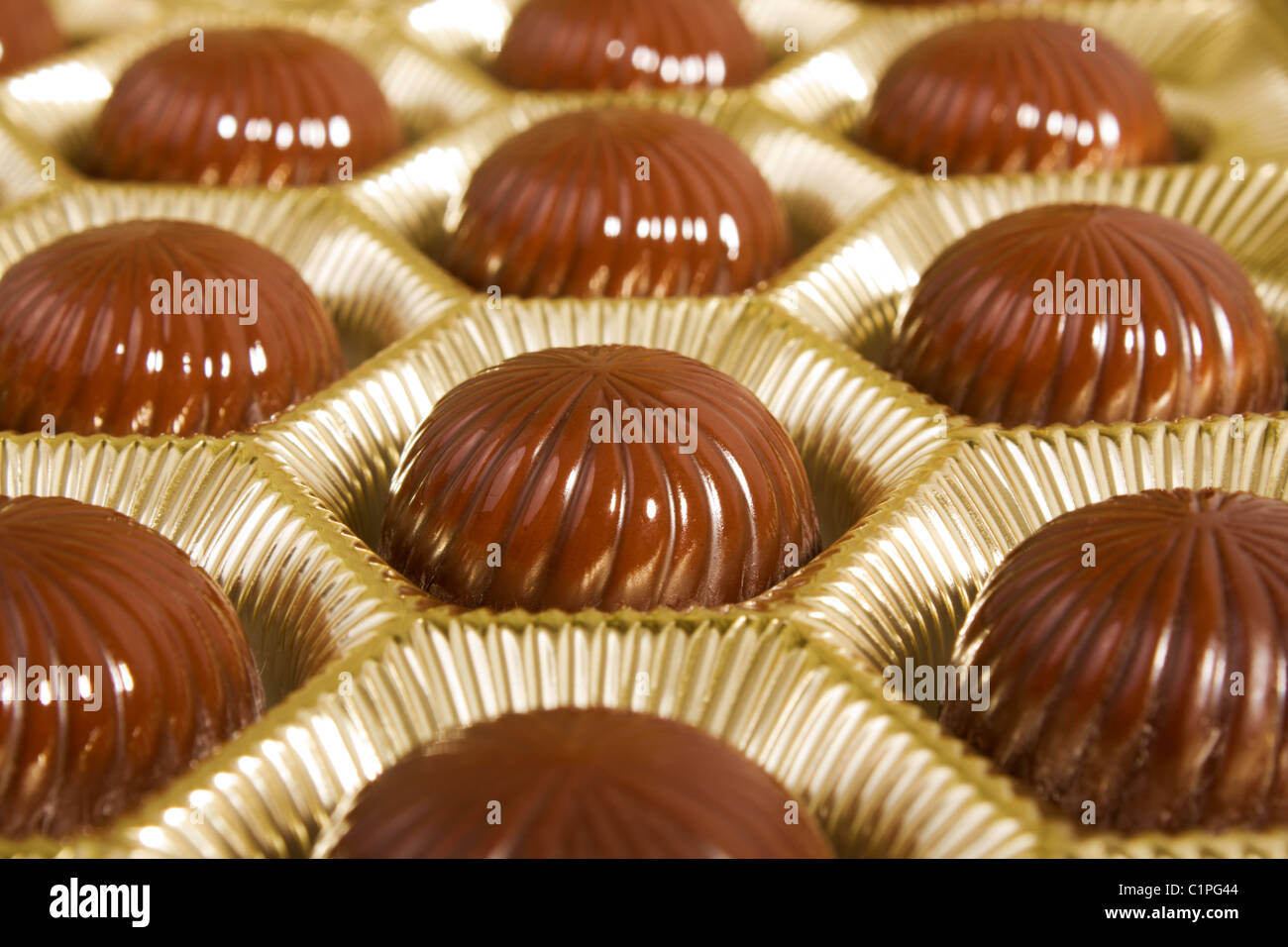 Box of chocolates inside. Dark chocolate in gold foil Stock Photo - Alamy