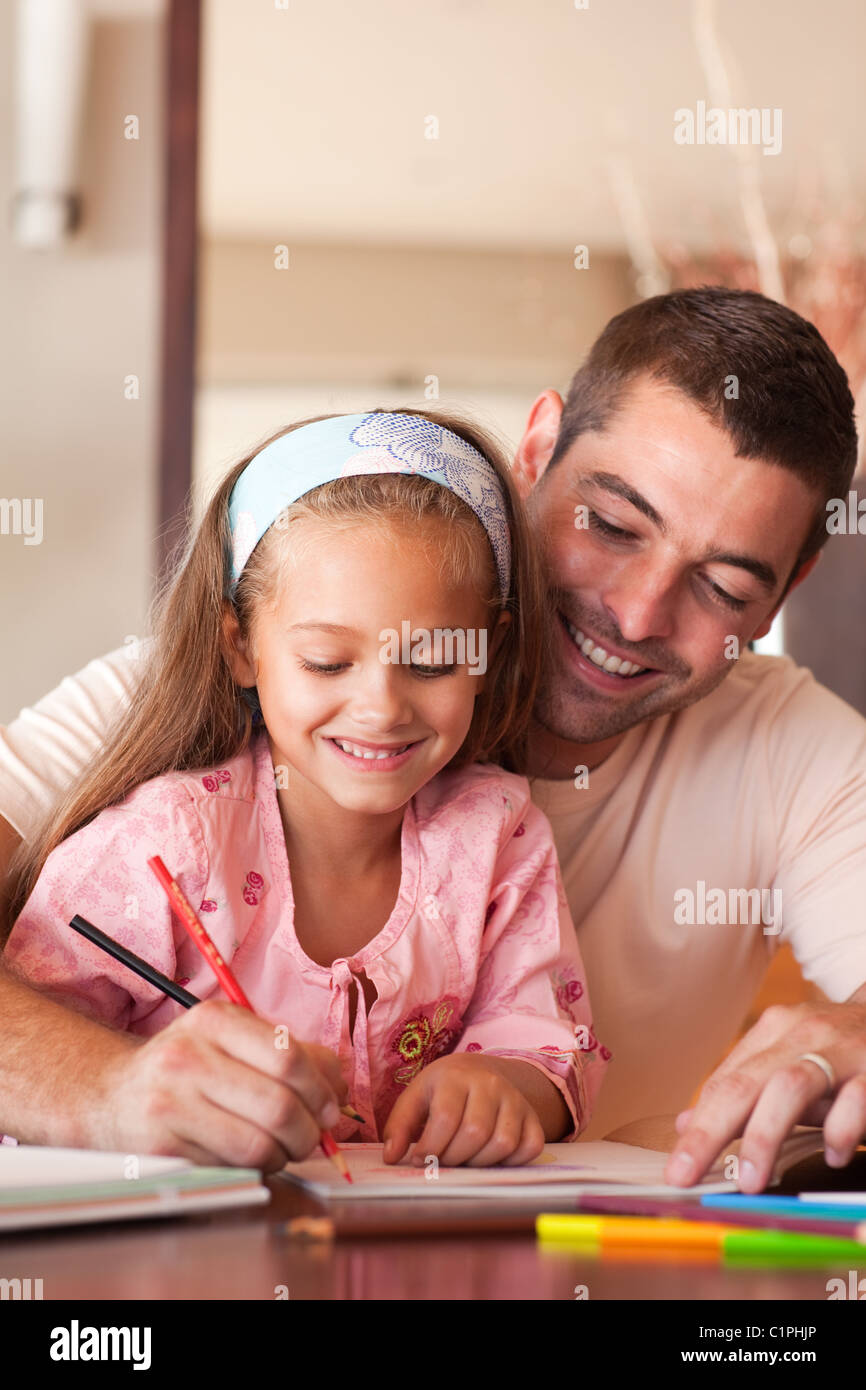 Delighted family drawing with colourful pen Stock Photo - Alamy