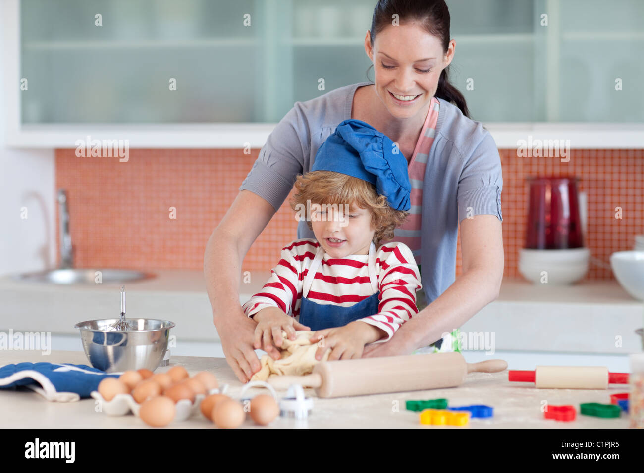 Glowing mother helping her son Stock Photo - Alamy