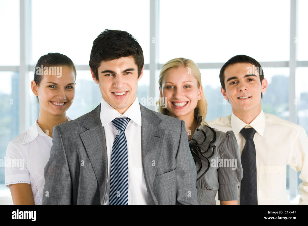 Photo of successful employer looking at camera with his colleagues at ...