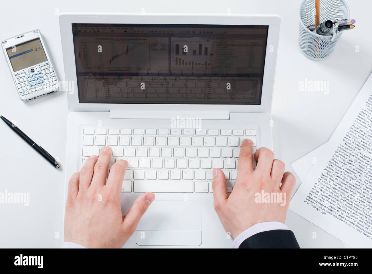 Above view of male hands pushing buttons of laptop with smartphone and ...
