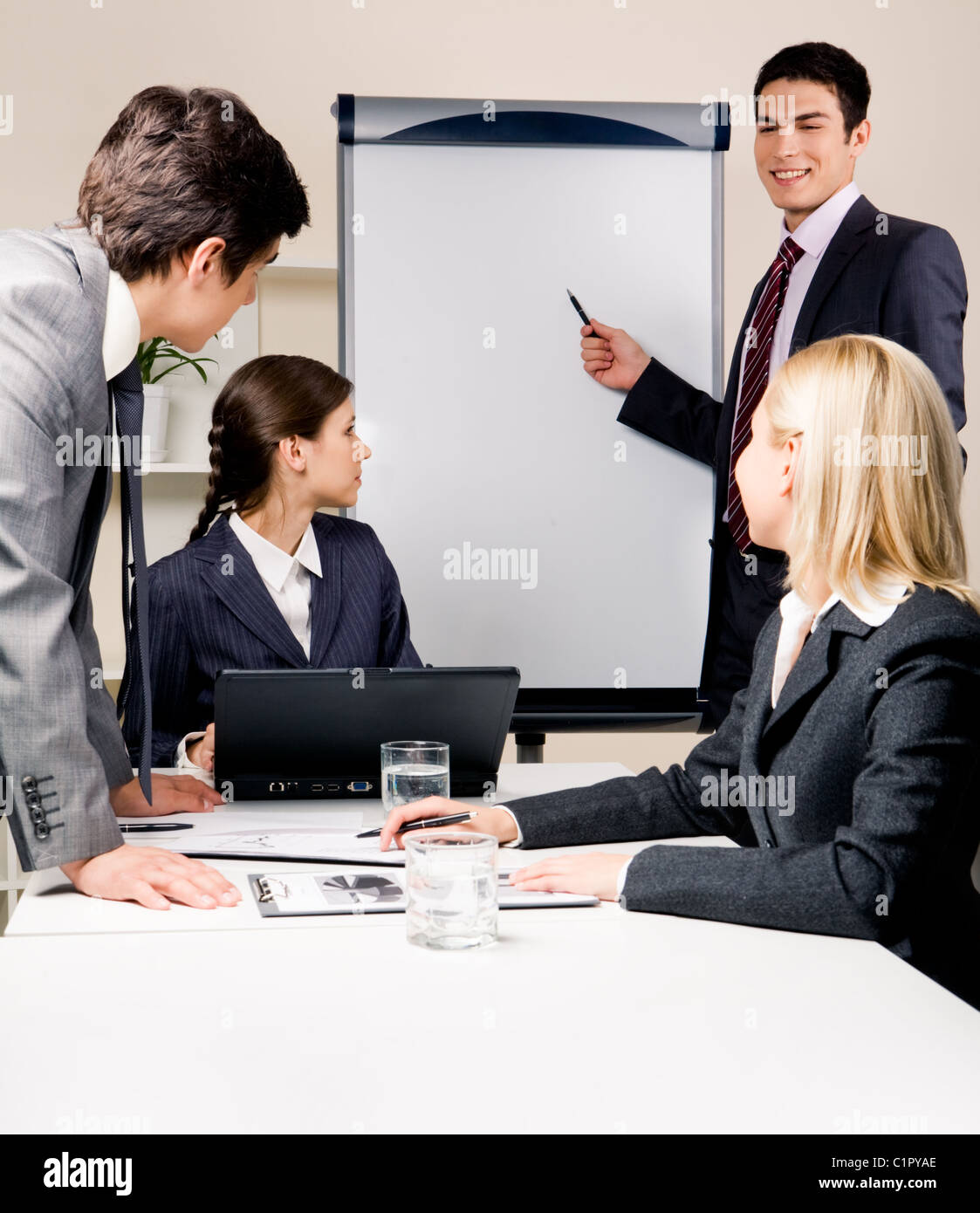 Photo of serious partners listening to successful businessman reading ...