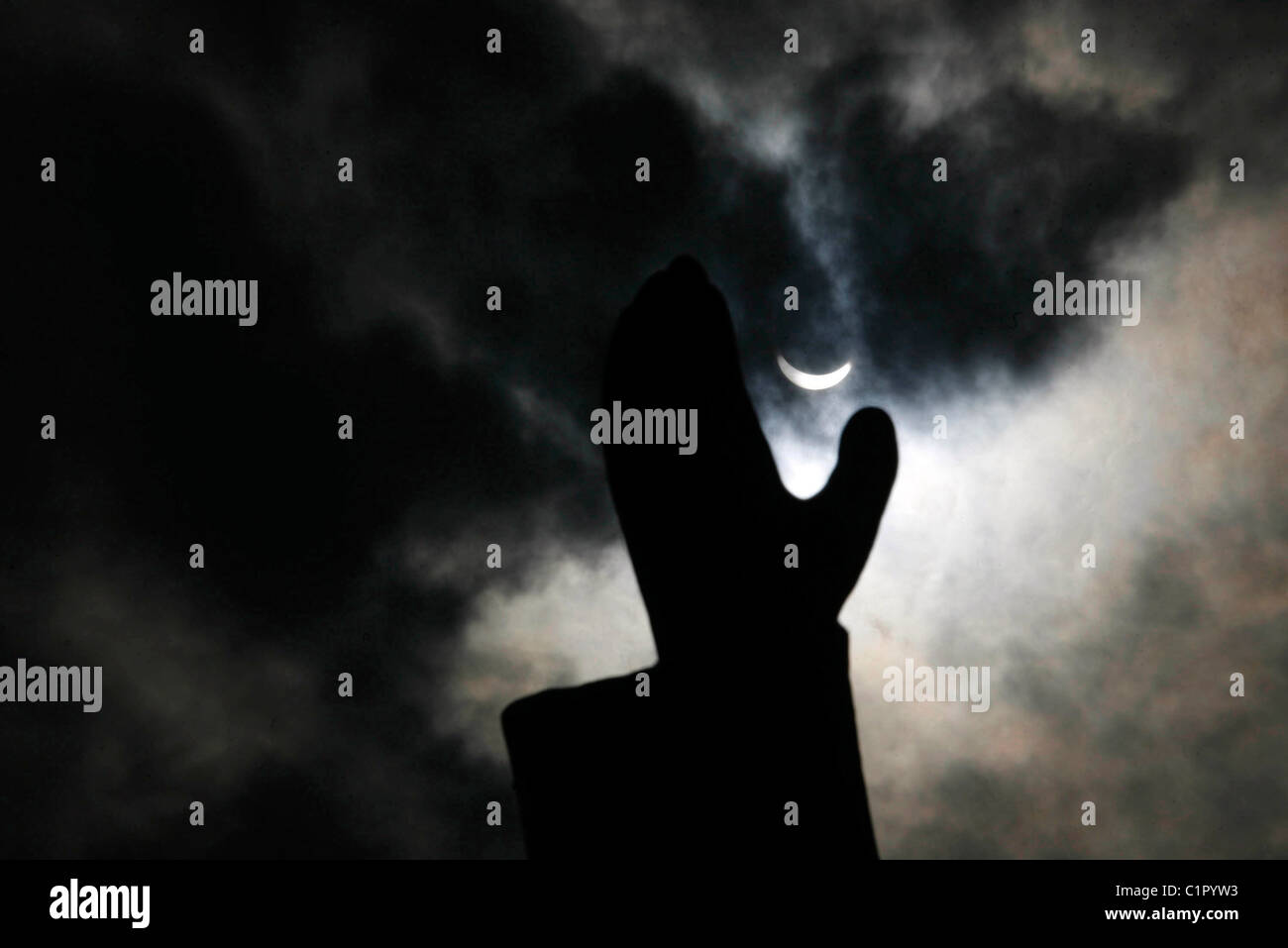 A solar eclipse is seen in the sky above Chairman Mao's statue in Wuhan ...