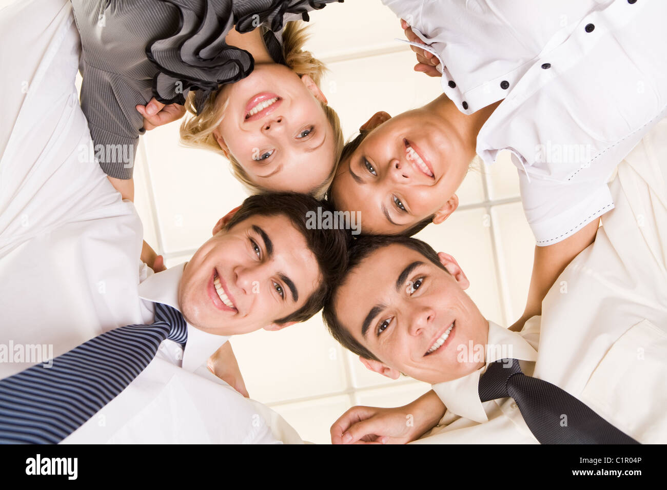 Faces of several successful partners looking at camera with happy ...