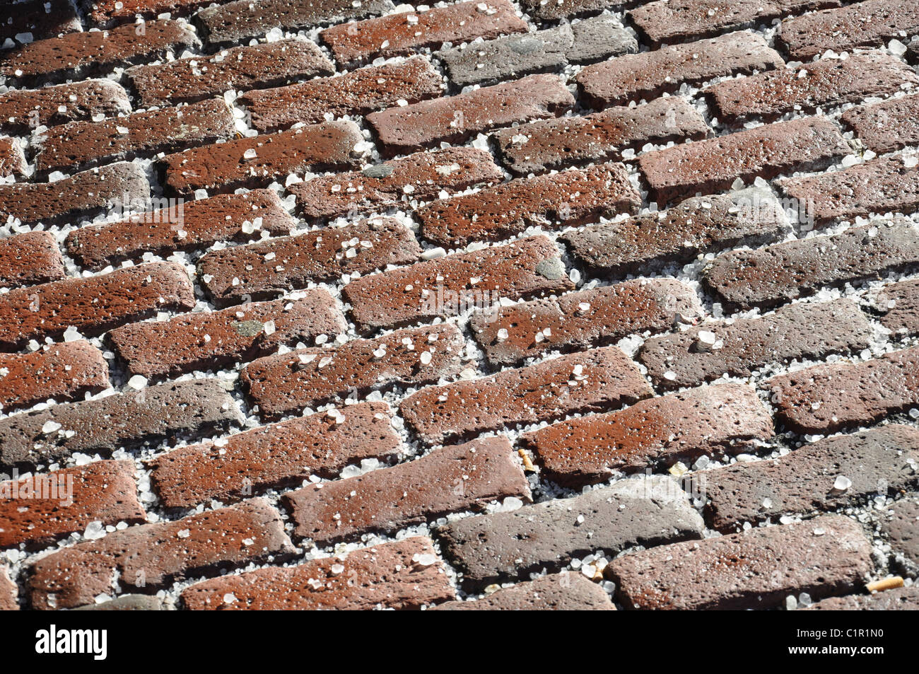 a red brick walkway covered in salt in bright sunlight Stock Photo - Alamy