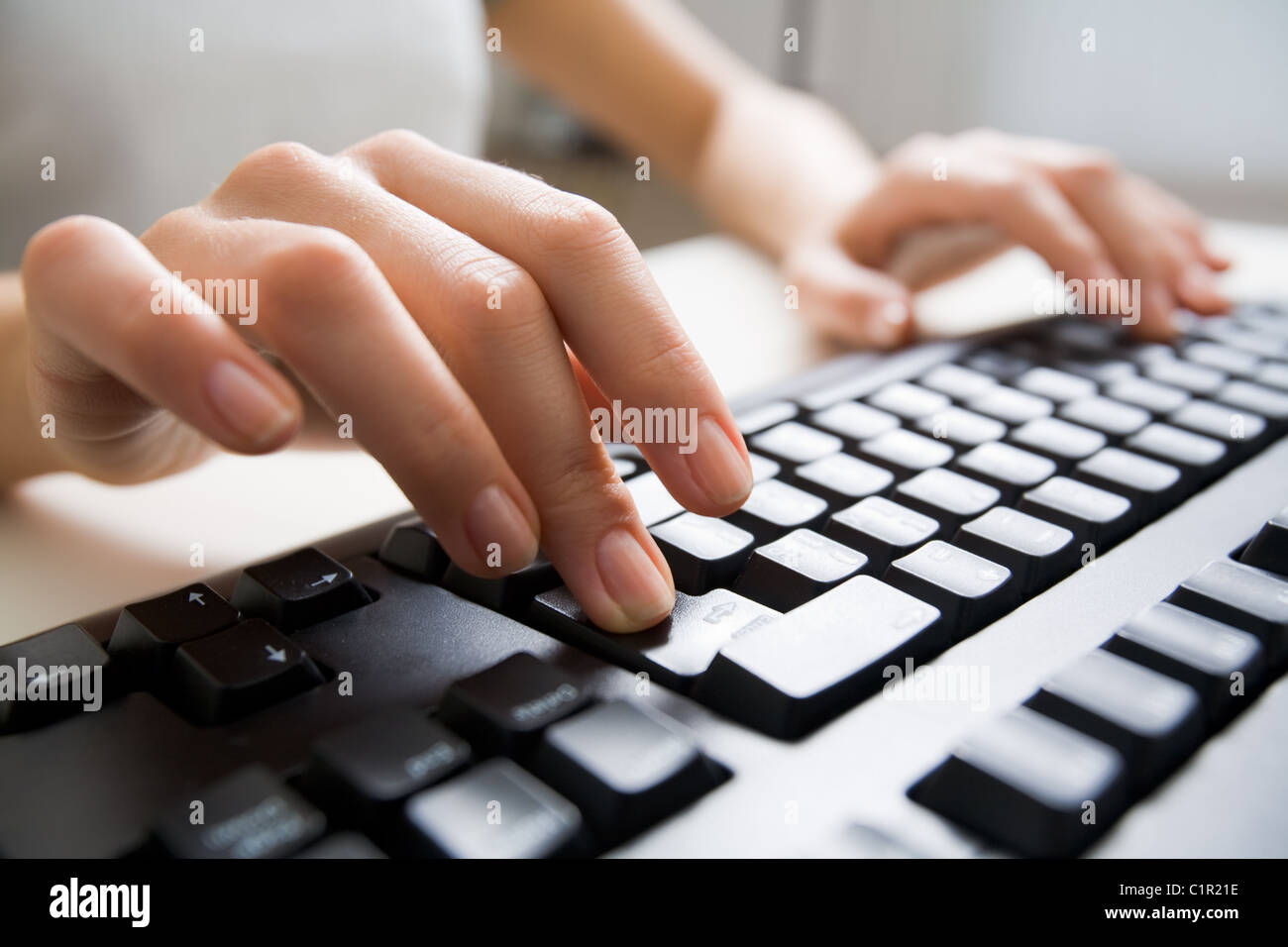 Close-up of female hands touching buttons of black computer keyboard ...