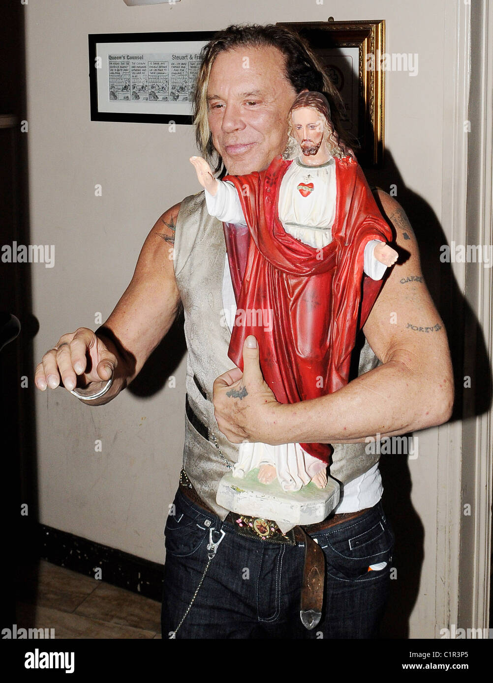 Mickey Rourke holding a bust of Jesus Christ as he leaves the ...