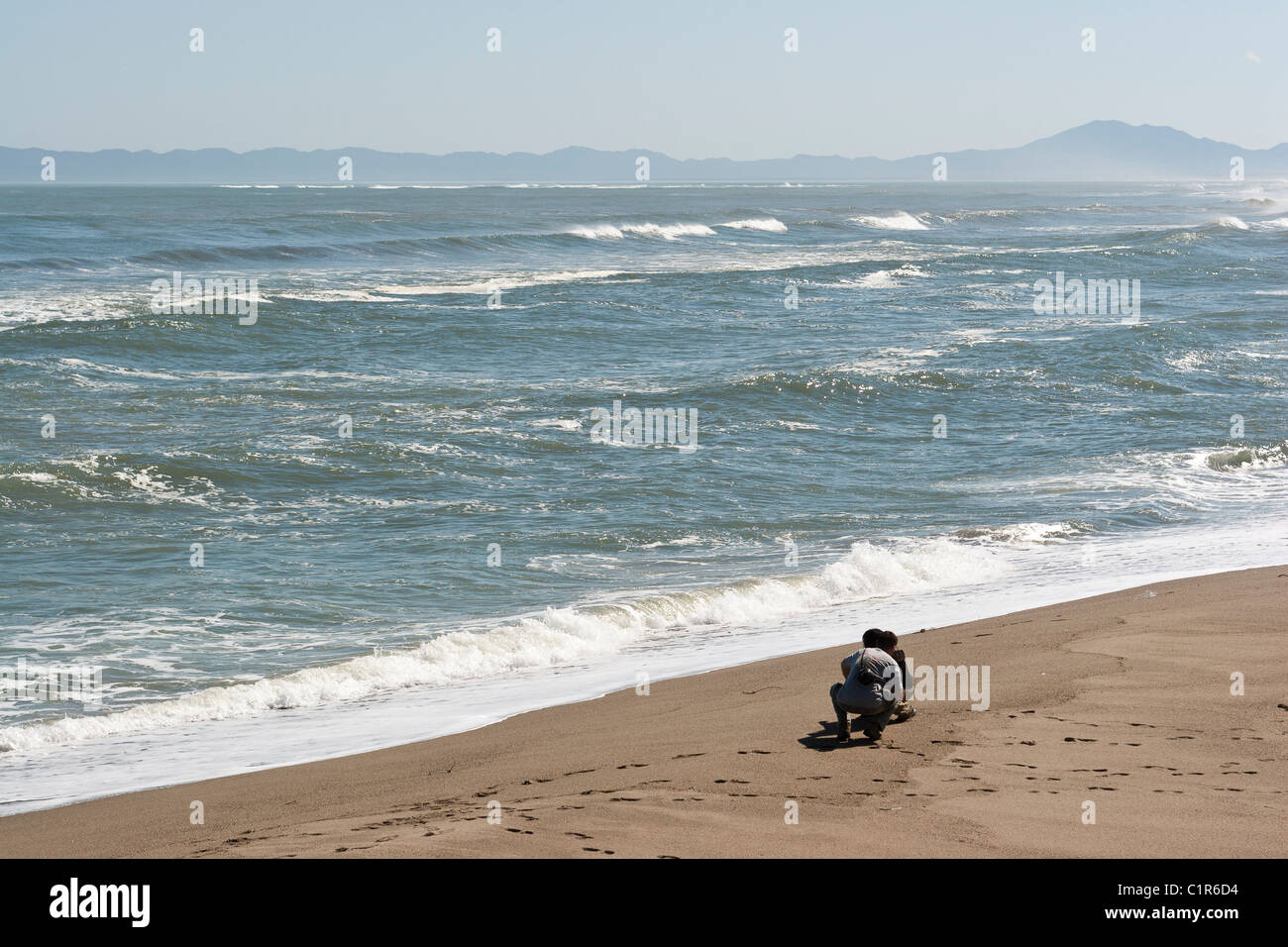 People walk along the beach in Okhotsk, Sakhalin, Russia. September ...