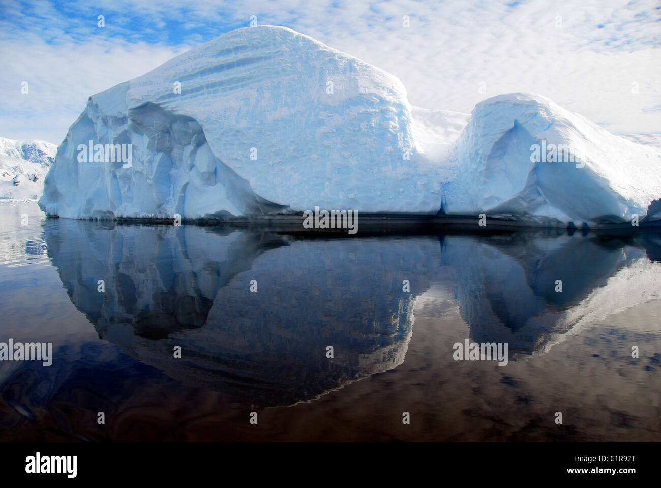 rounded iceberg floating in the ocean, reflected in water Stock Photo ...