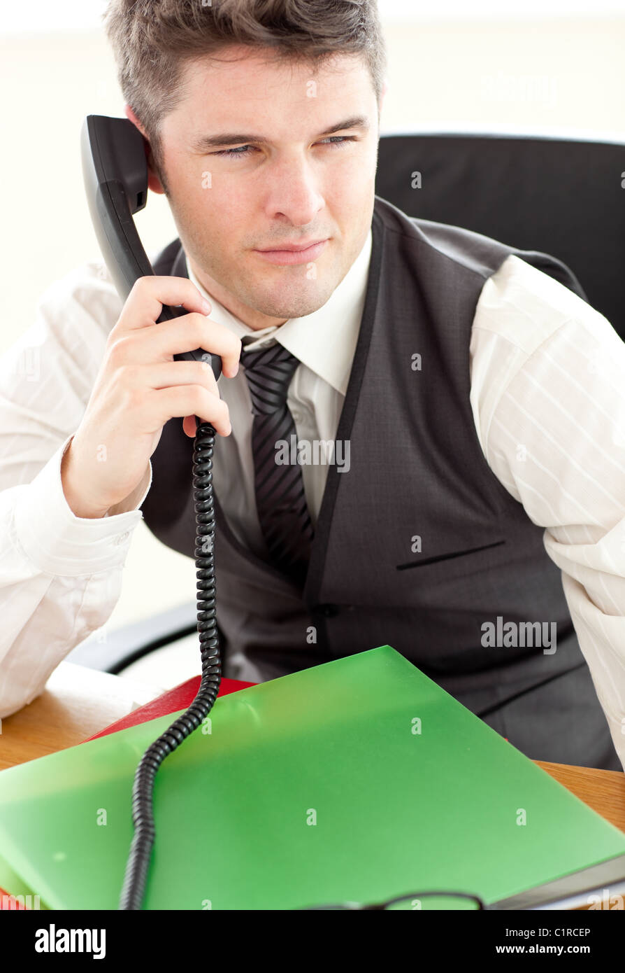 Self-assured businessman talking on phone at office Stock Photo - Alamy