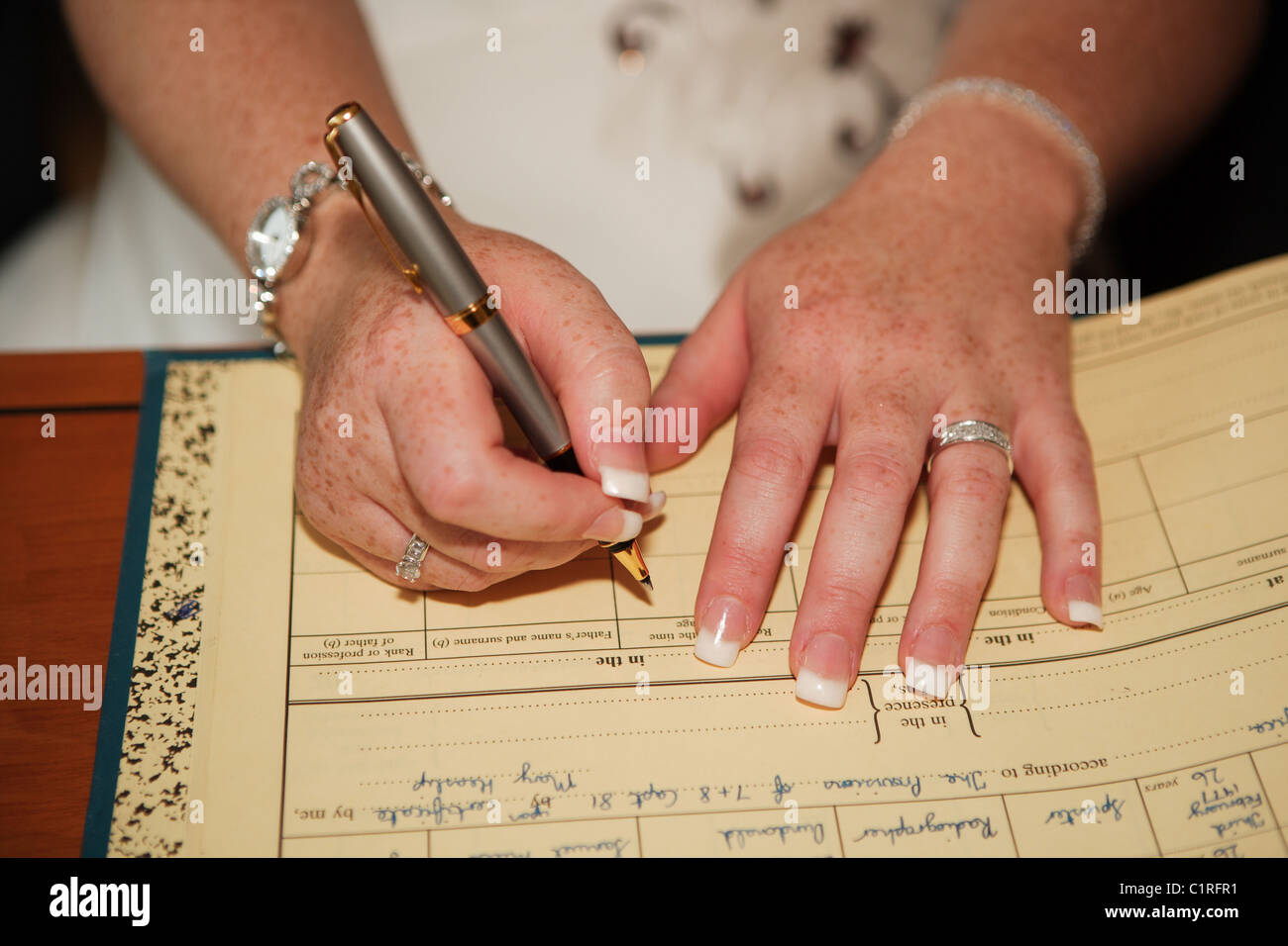 Bride signing wedding register with pen wedding ring on hand Stock ...