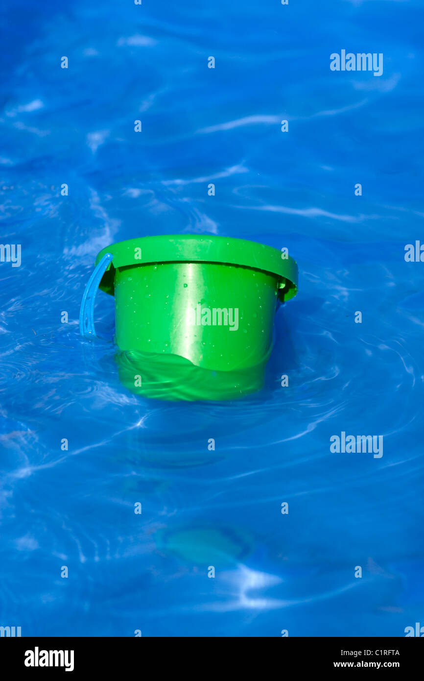 Green bucket floating in pool Stock Photo - Alamy