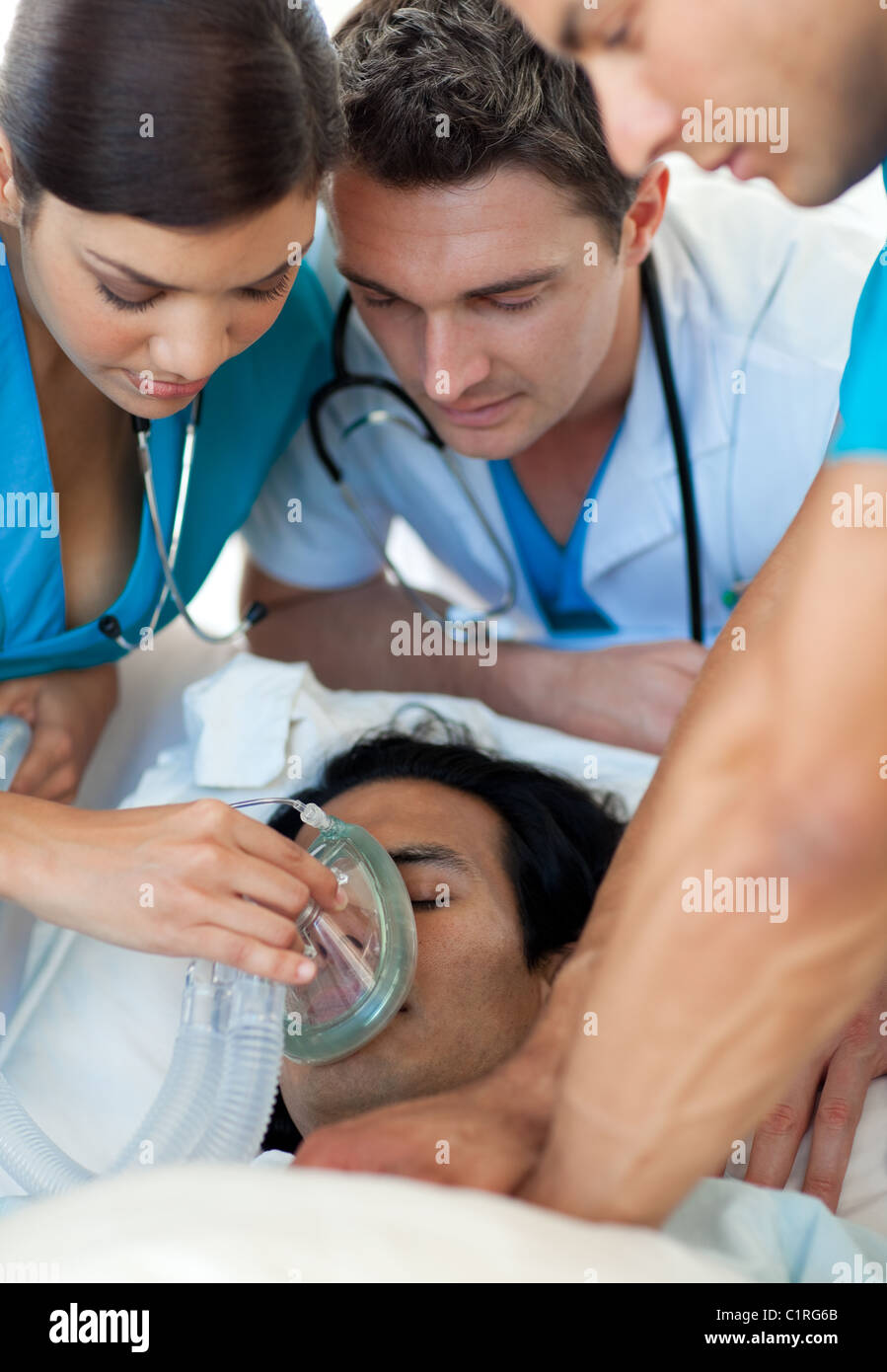Male doctor putting an oxygen mask to a patient hi-res stock ...