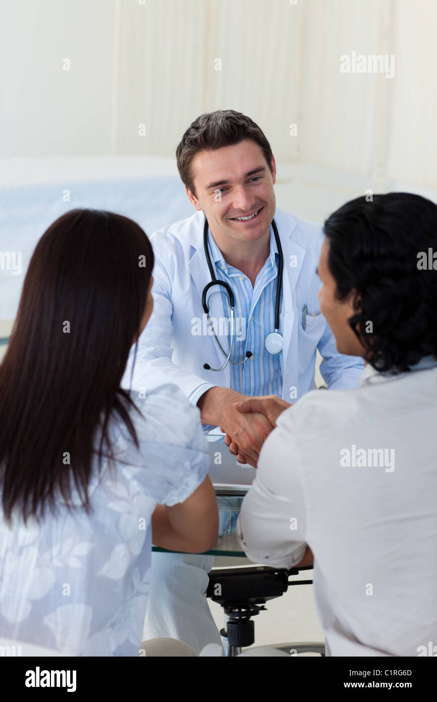 Smiling doctor explaining diagnosis to a couple Stock Photo - Alamy