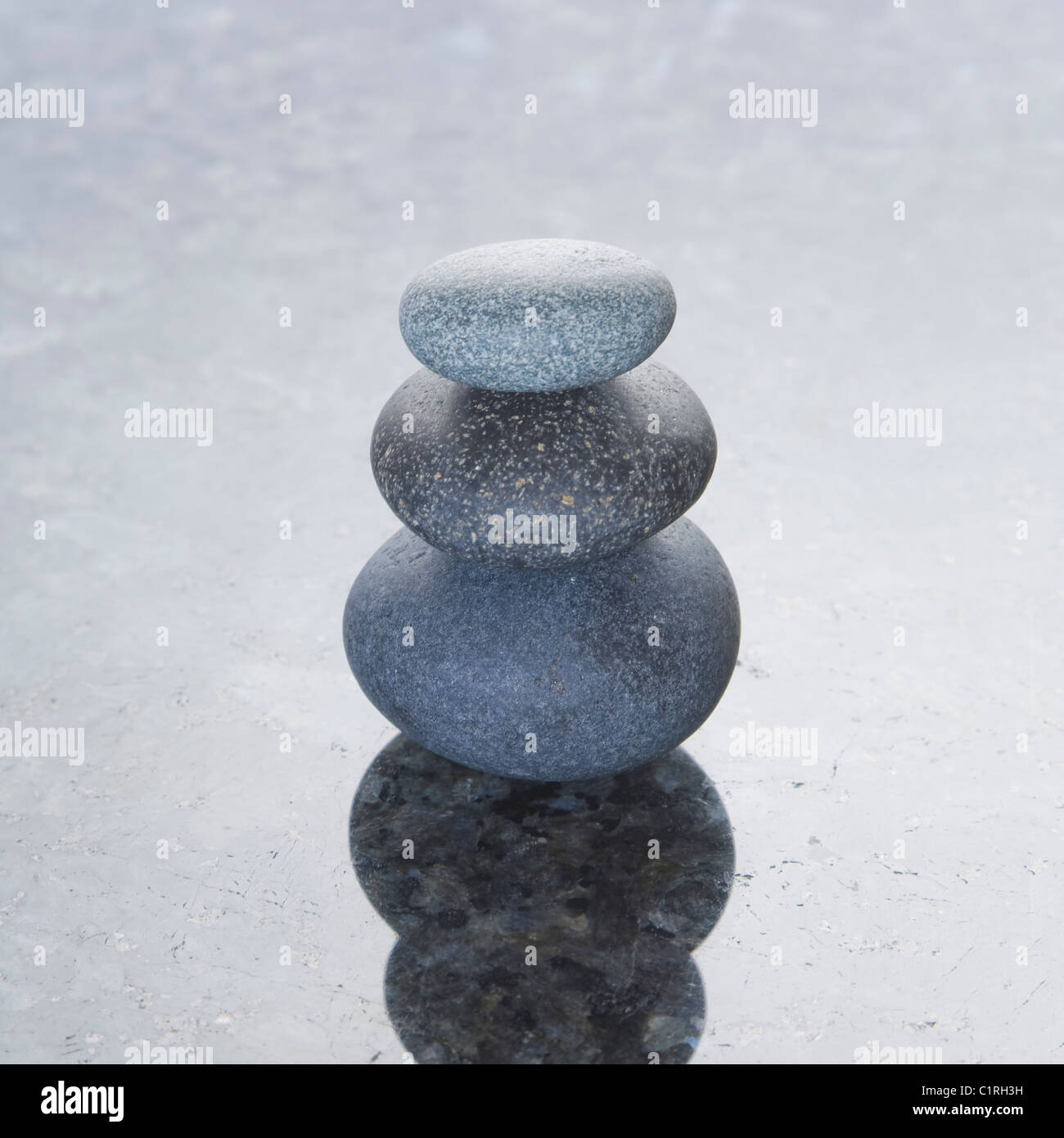 Stack of zen pebbles on a shiiny surface Stock Photo - Alamy