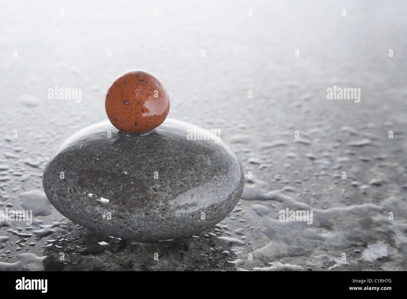 Stack of zen pebbles on a shiny, wet surface Stock Photo - Alamy