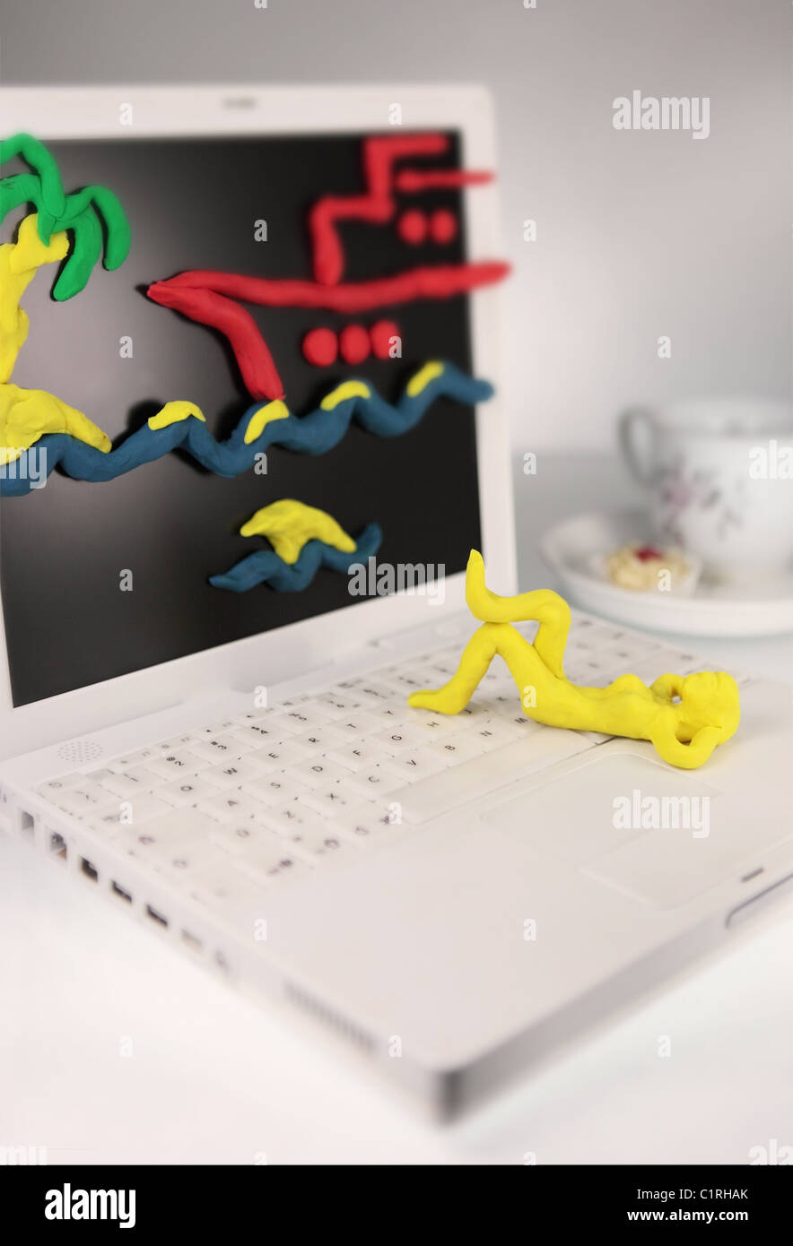 yellow modelling clay figurine resting on a white laptop and dreaming ...