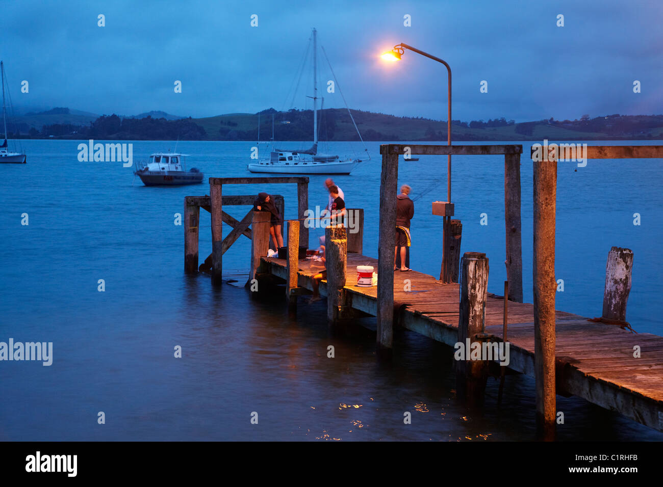 Fishing from the wharf at dusk, Mangonui Harbour, Mangonui, Northland ...