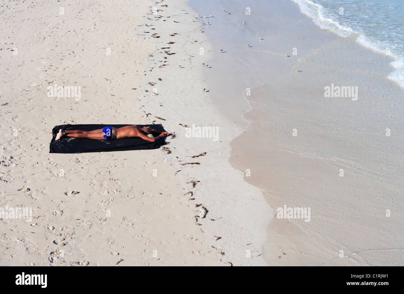 Man sunbathing on a beach hi-res stock photography and images - Alamy