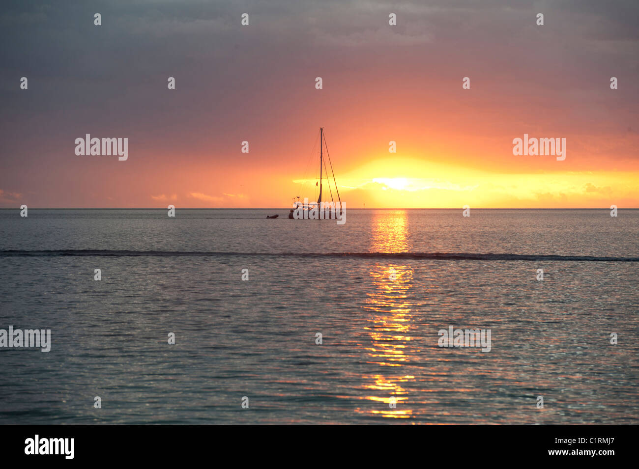 peaceful scene of sailboat sailing into sunset Stock Photo - Alamy