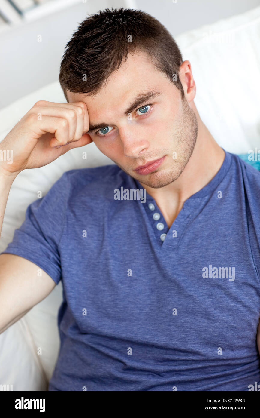 Bored young man sitting on the sofa Stock Photo - Alamy