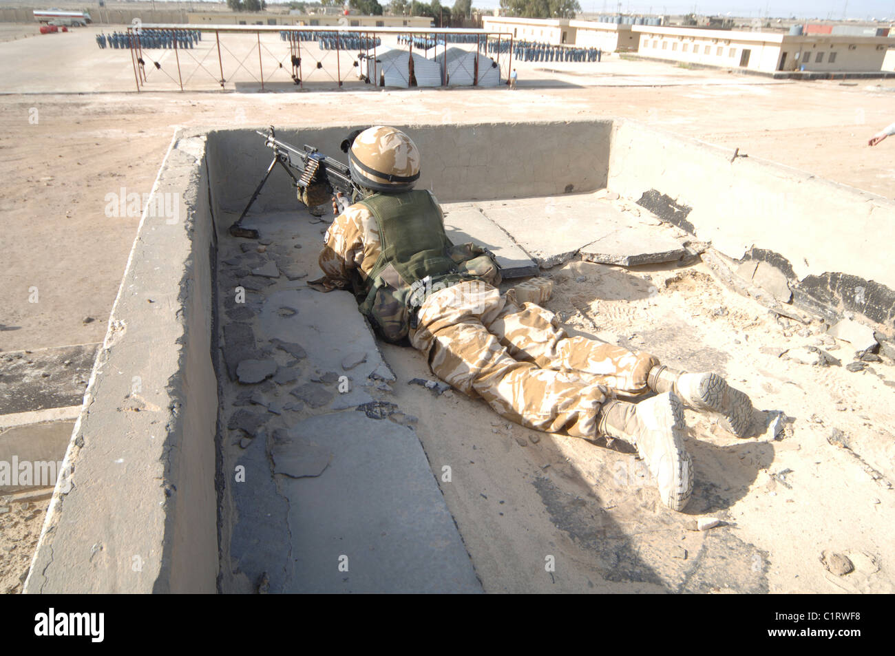 A British Army soldier provides security from a rooftop in Basra, Iraq ...