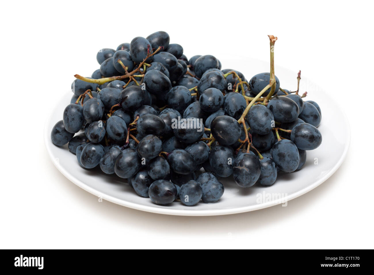 Blue grape put on plate on white background Stock Photo - Alamy